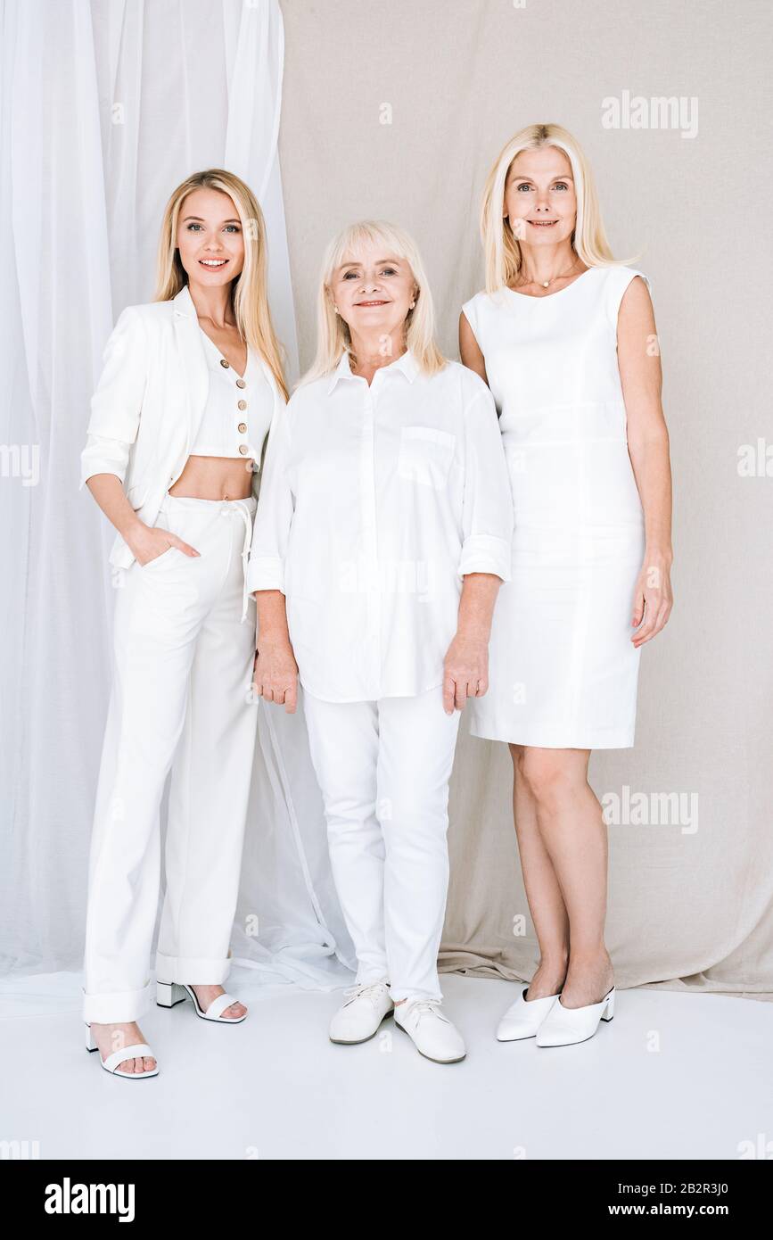 full length view of three generation blonde women in total white ...