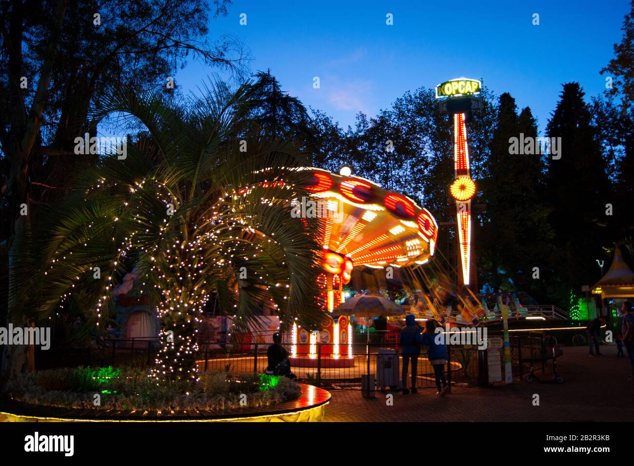 Carousel in bright lights on a dark summer south night against a ...