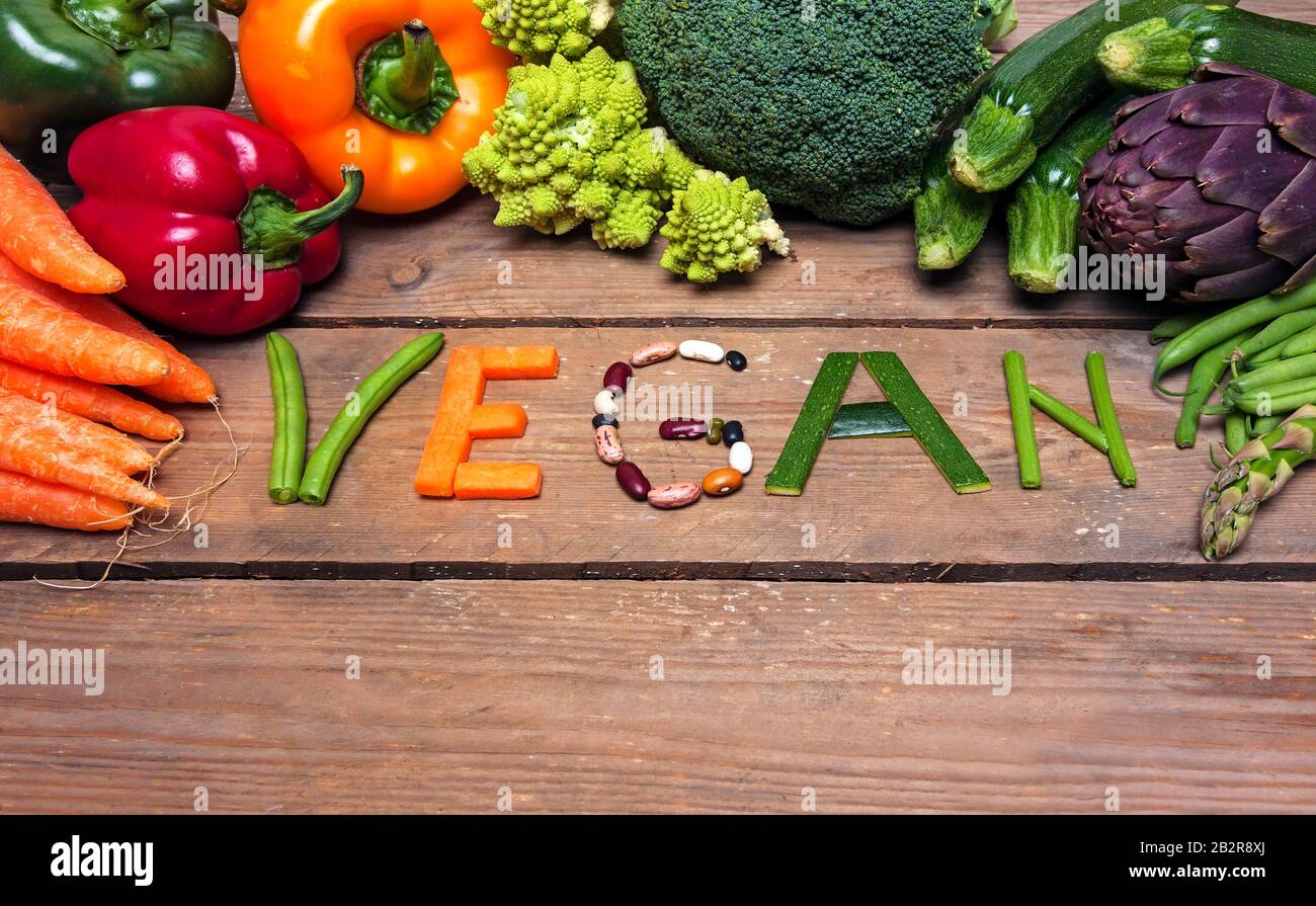 vegan word on wood background and vegetable - food Stock Photo - Alamy