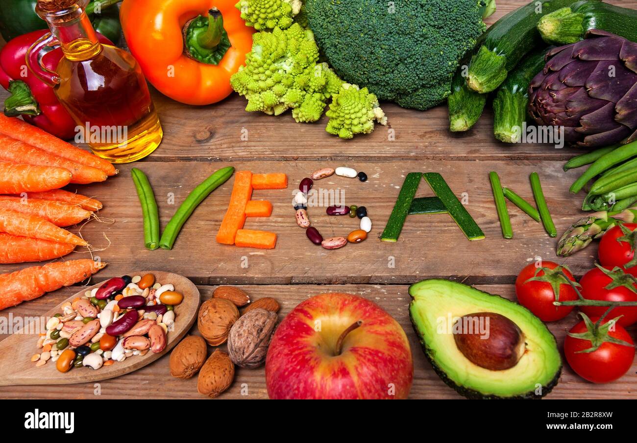 vegan word on wood background and vegetable - food Stock Photo - Alamy