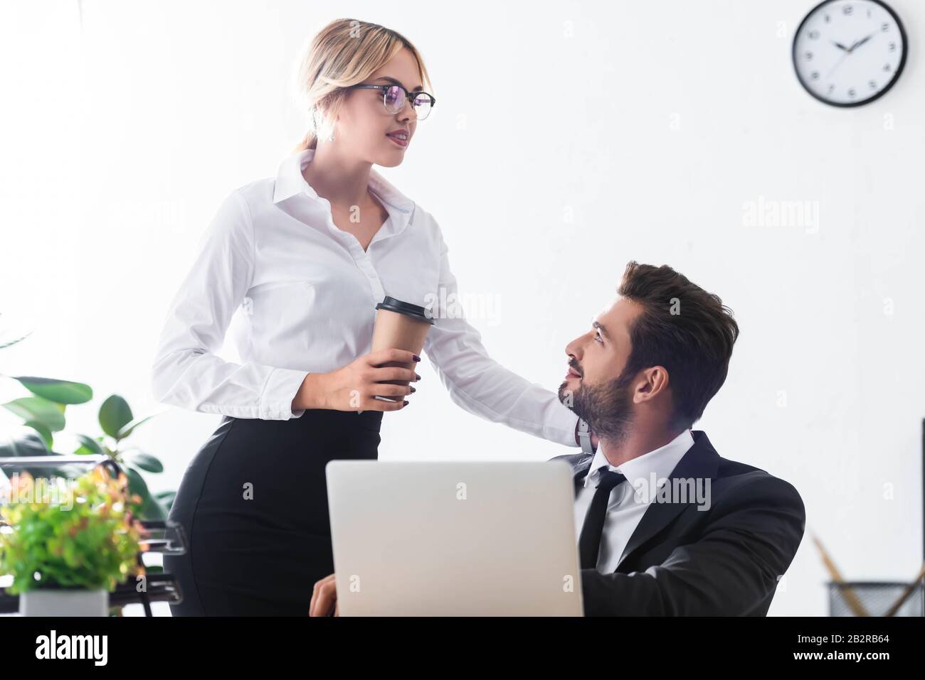 Secretary giving coffee to smiling businessman in office Stock Photo ...