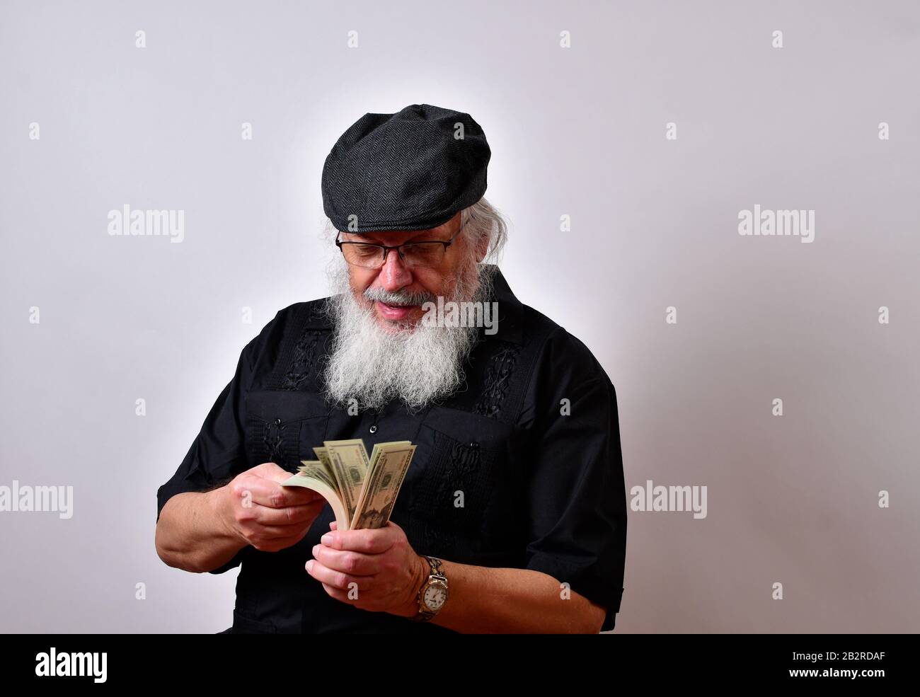 With beard counting his money while standing on the white background ...