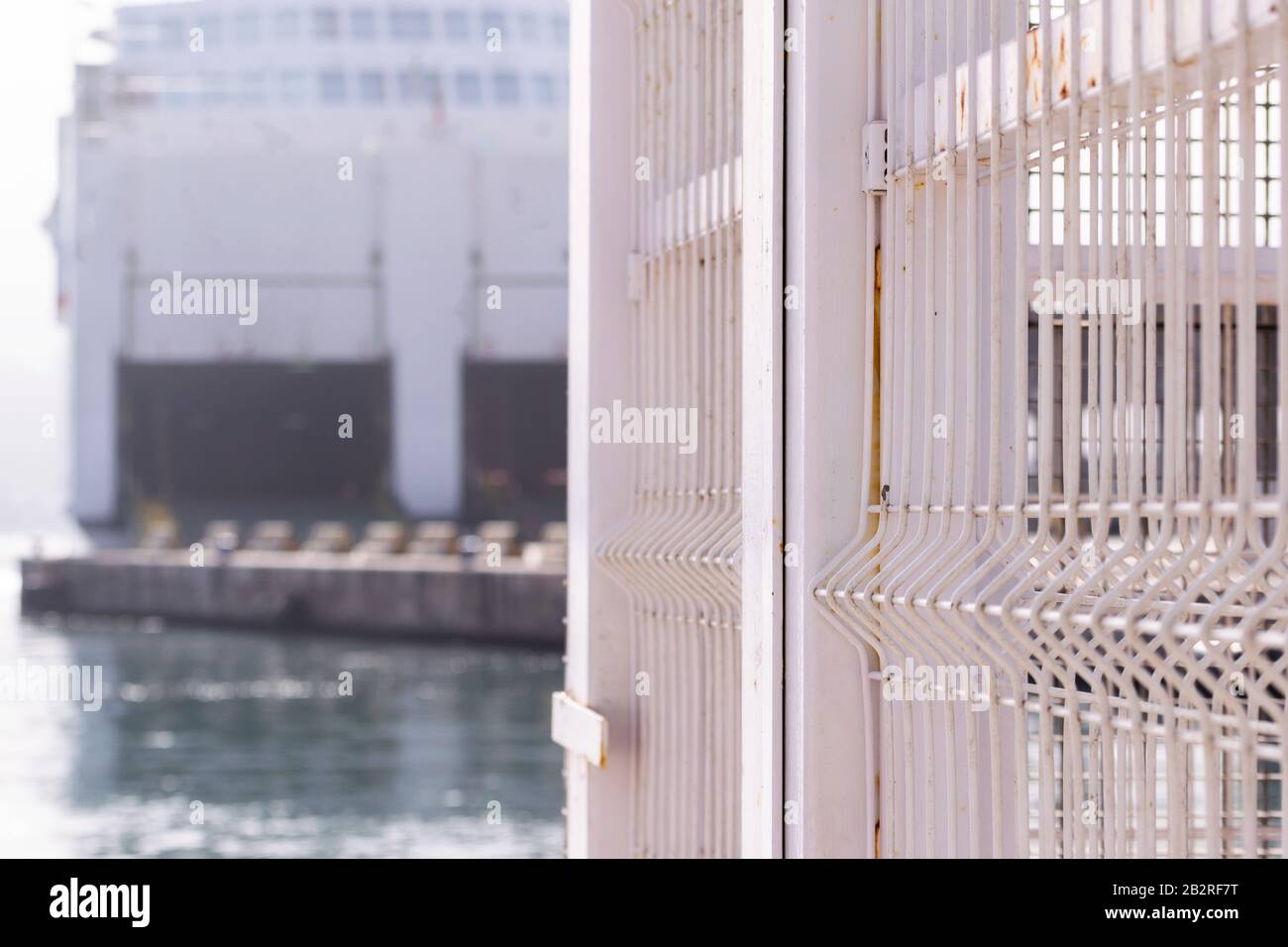 Close up selective focus on metallic white big gate with rear view of a ...