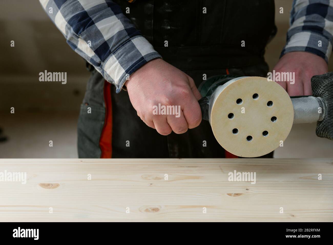 Carpentry. Wood sanding. Orbital sander for woodworking. In a natural ...