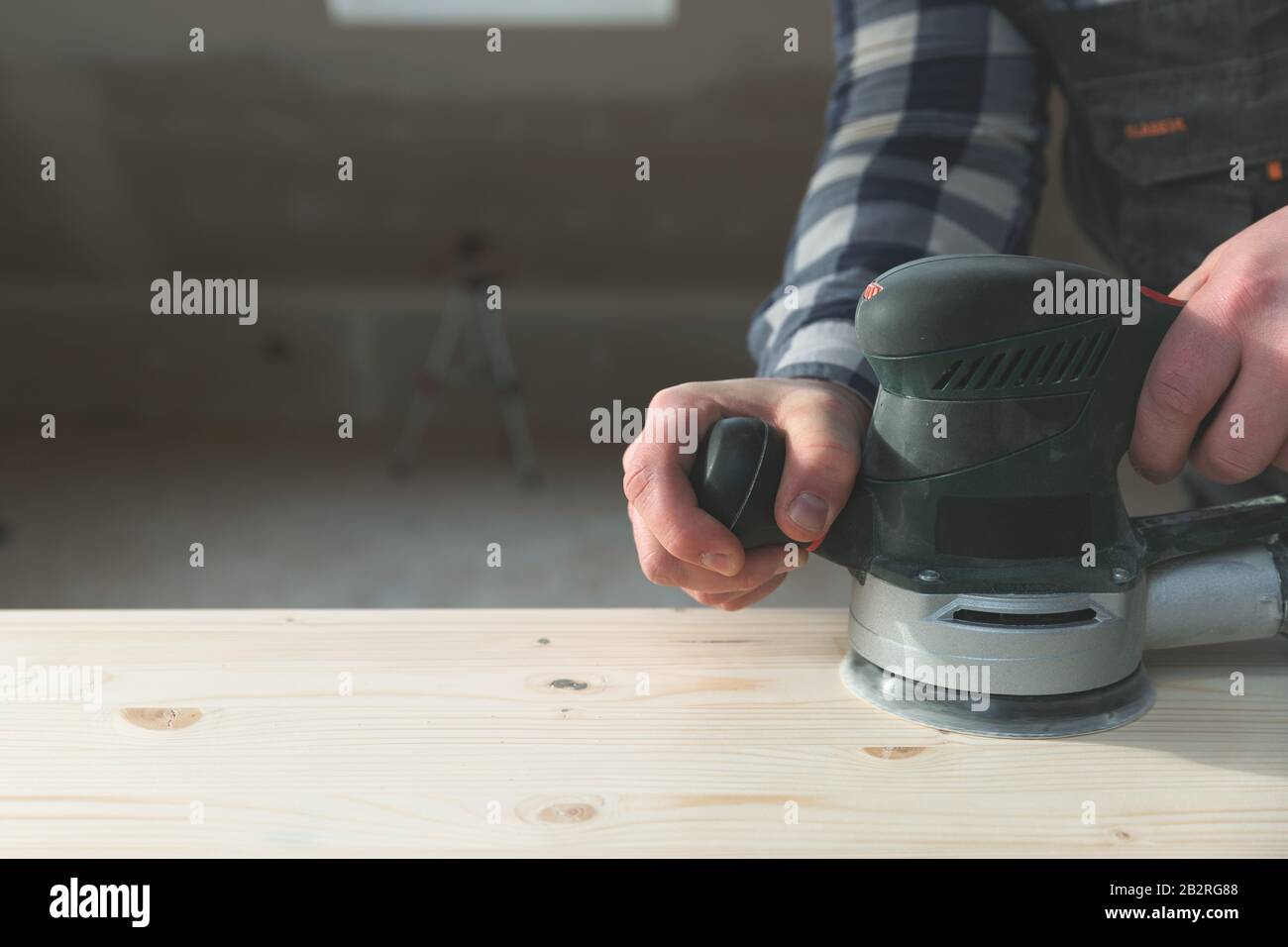 Carpentry. Wood sanding. Orbital sander for woodworking. In a natural ...