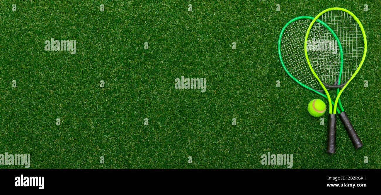 Top view of tennis rackets and ball of green grass. Horizontal sport ...