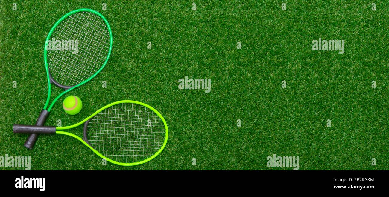 Top view of tennis rackets and ball of green grass. Horizontal sport ...