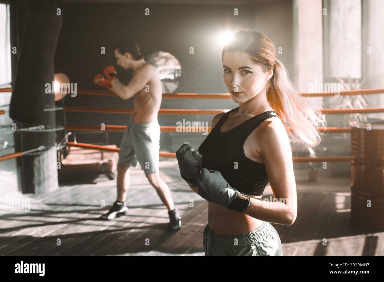 Female boxer doing shadow boxing inside a boxing ring. Boxer practicing ...