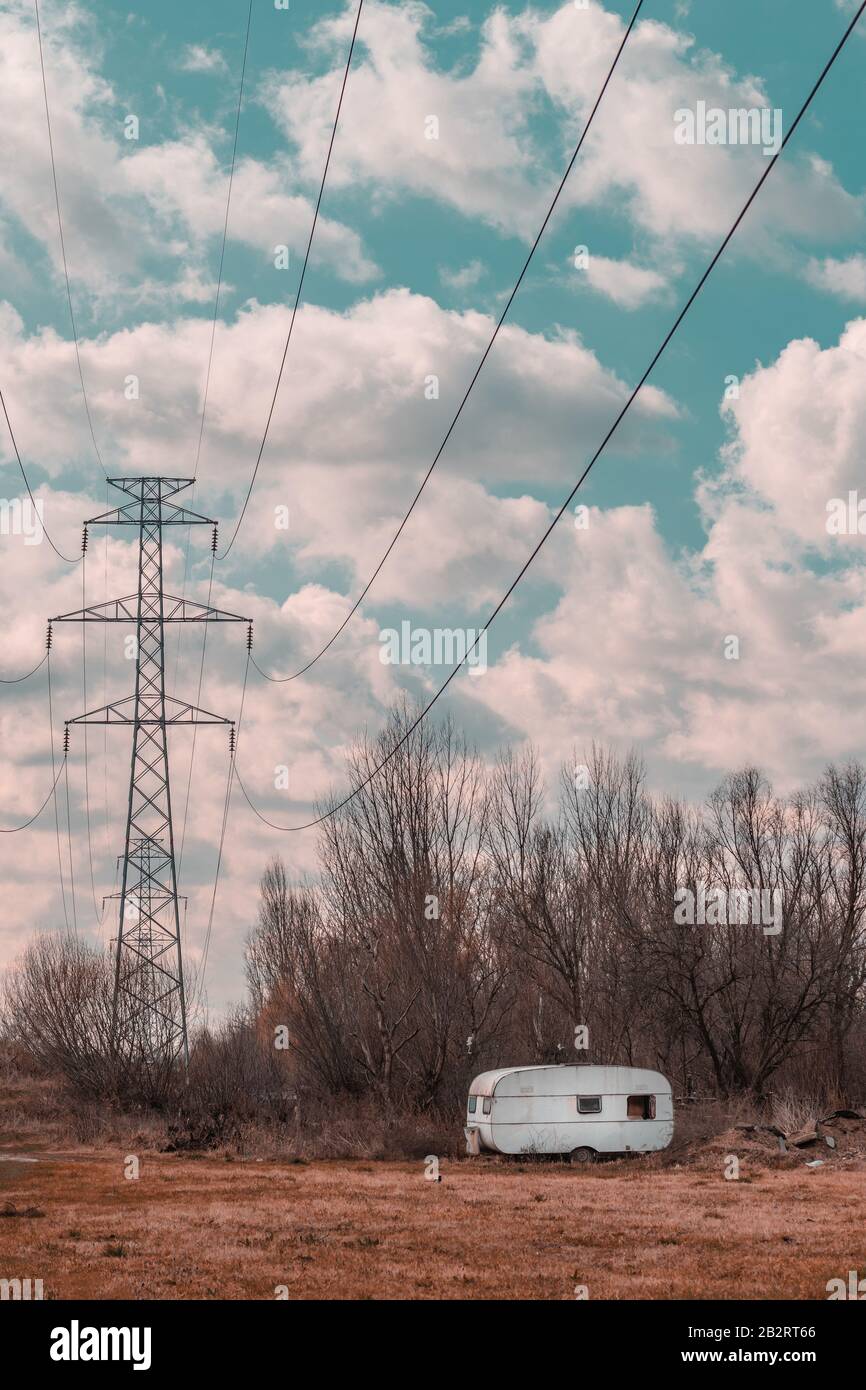 Abandoned camp car trailer in field with electricity pylons Stock Photo ...