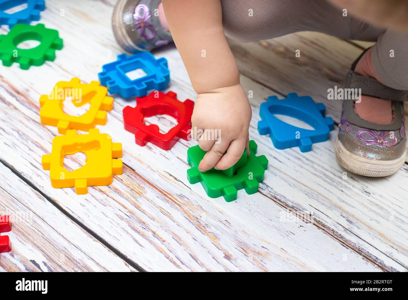 hand of child putting green action figure in Baby Blocks Shape Sorter ...