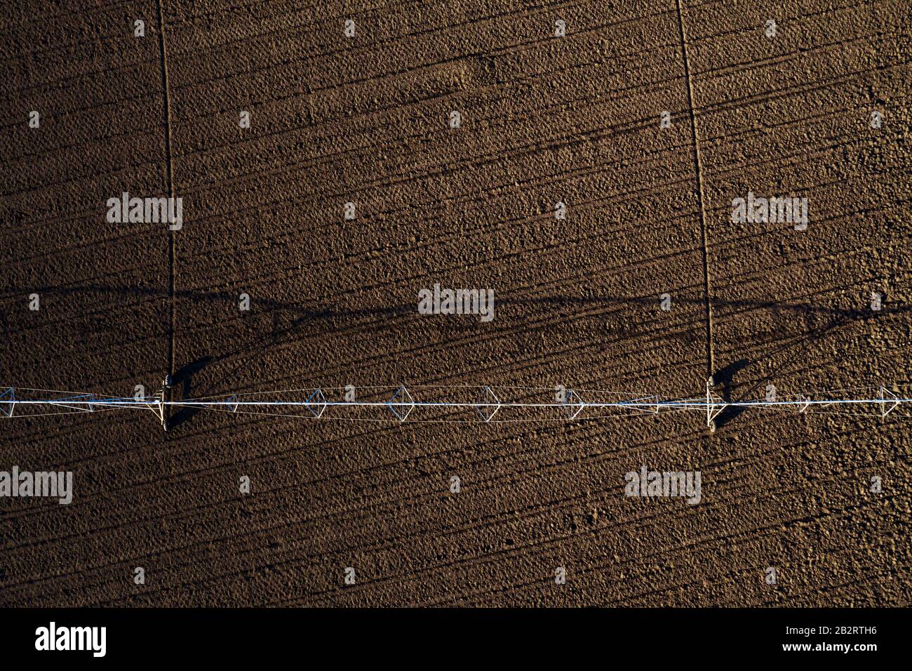 Aerial view of center-pivot irrigation system on plowed field from ...