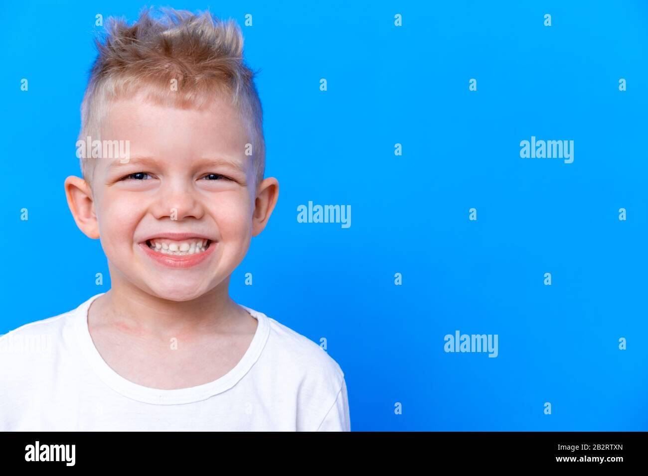 Portrait of happy child kid boy with wide smile on blue background ...