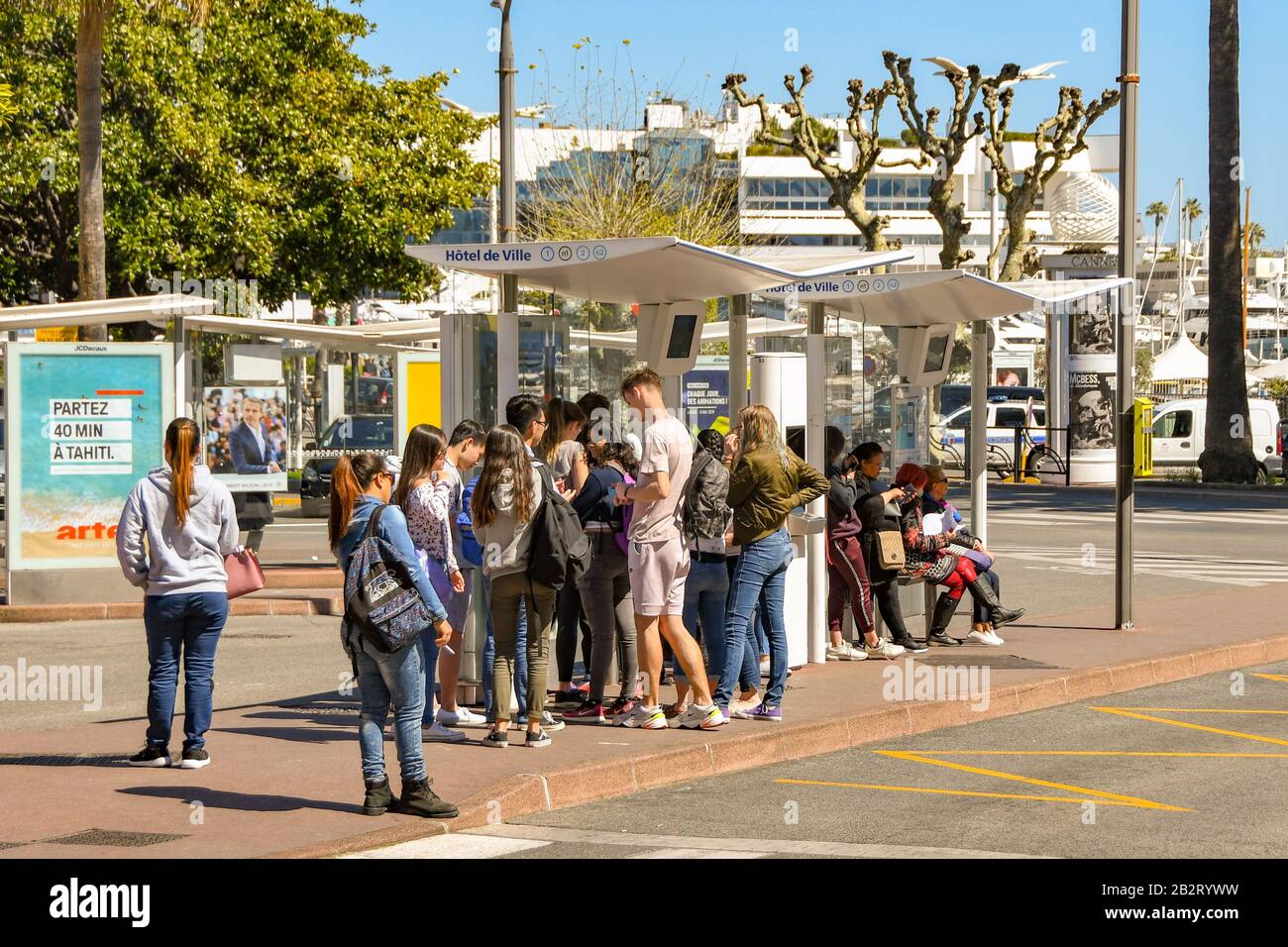 CANNES, FRANCE - APRIL 2019: Crowd of people waiting for a bus at a bus ...