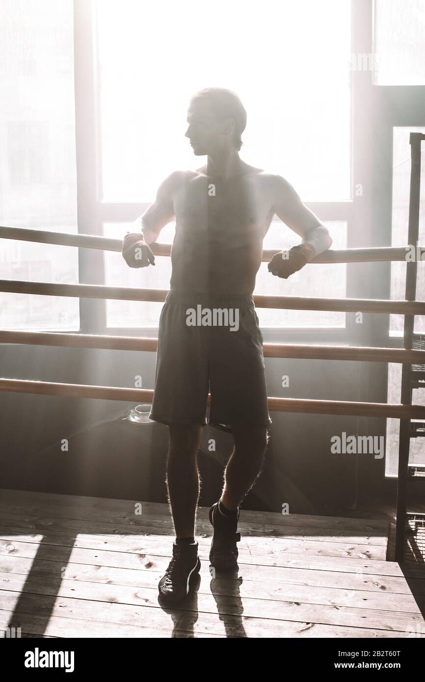 Portrait of sportive boxer wearing boxing bandages on hands while ...