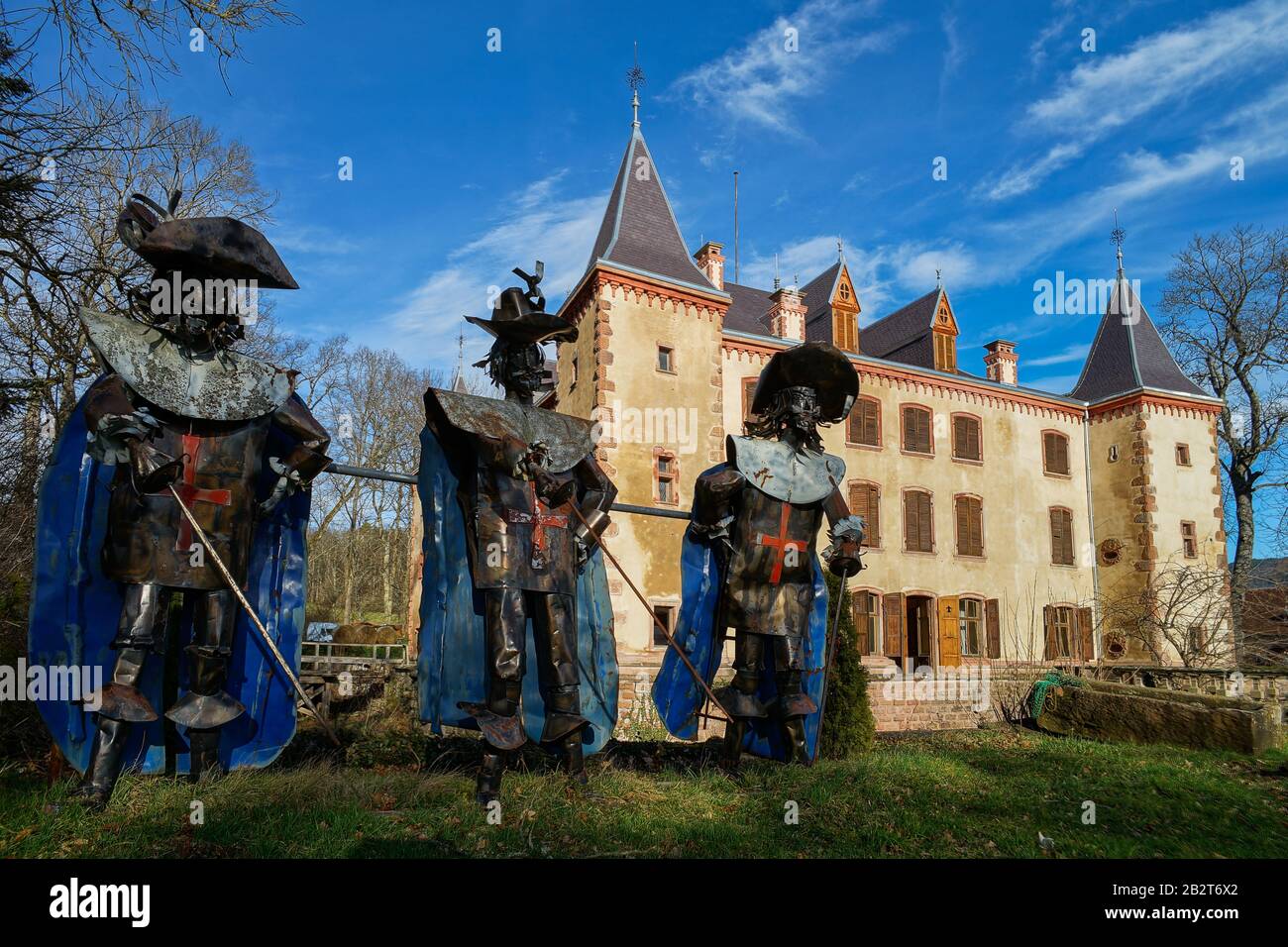 Iron statues of french musketeers on the background of an old castle ...