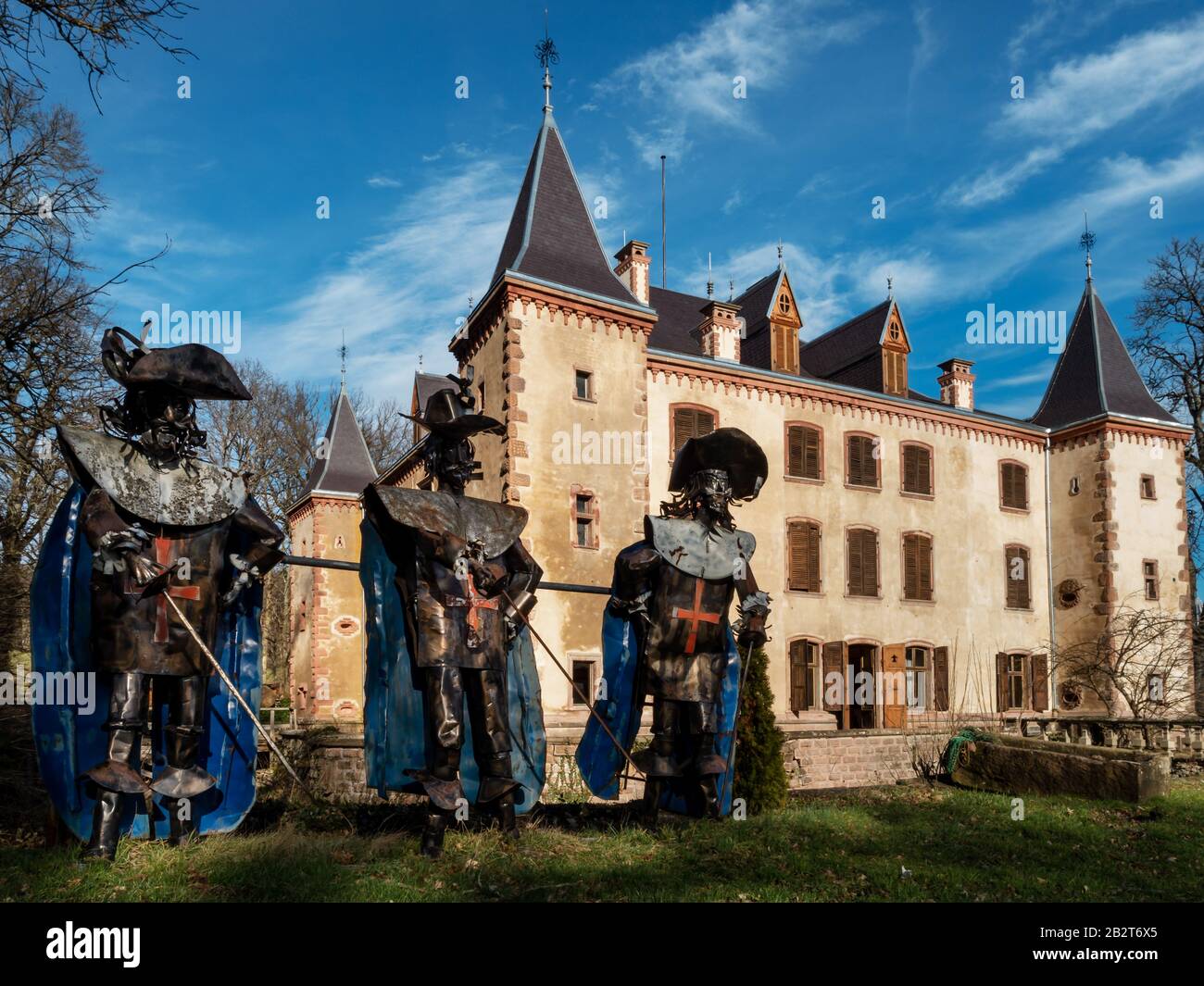 Iron statues of french musketeers on the background of an old castle ...