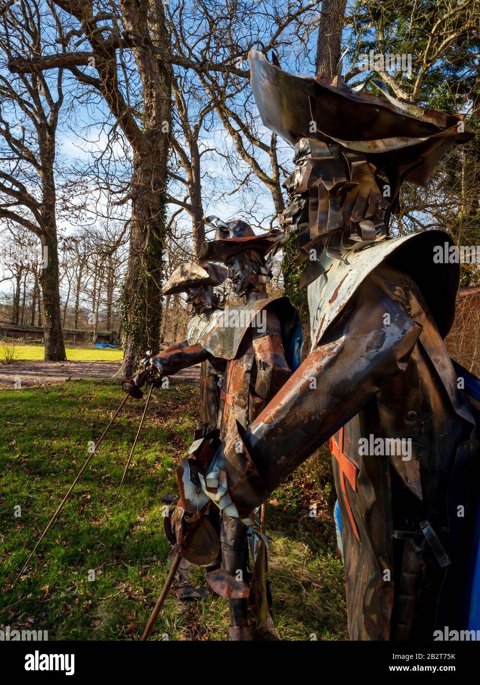 Iron statues of french musketeers on the background of an old castle ...