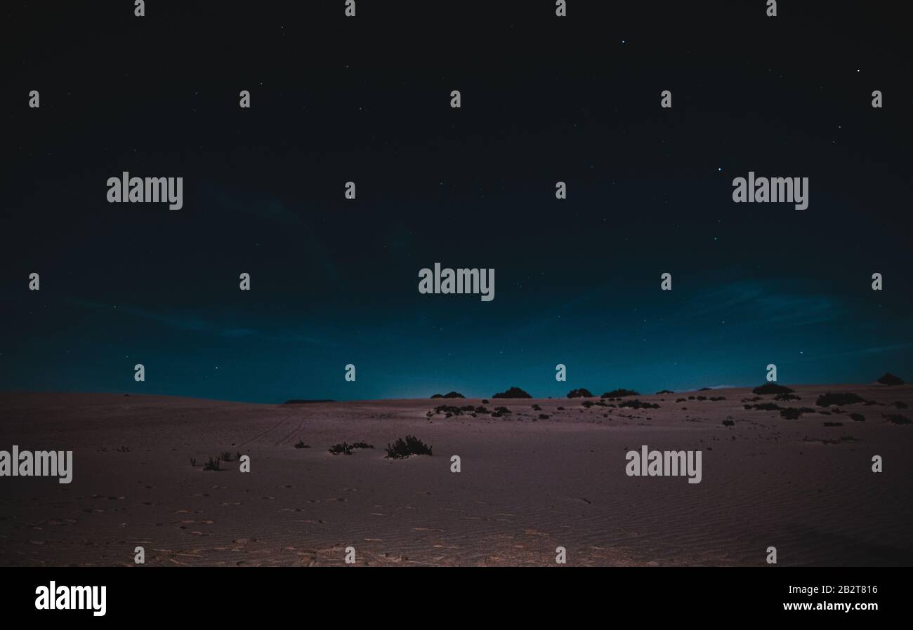 Beautiful scenery of the blue night sky over the sandy land Stock Photo ...