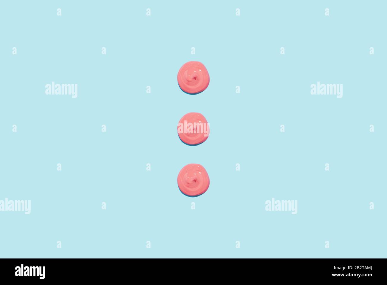 Three spots of pink paint on a blue background. Cream, cosmetic ...