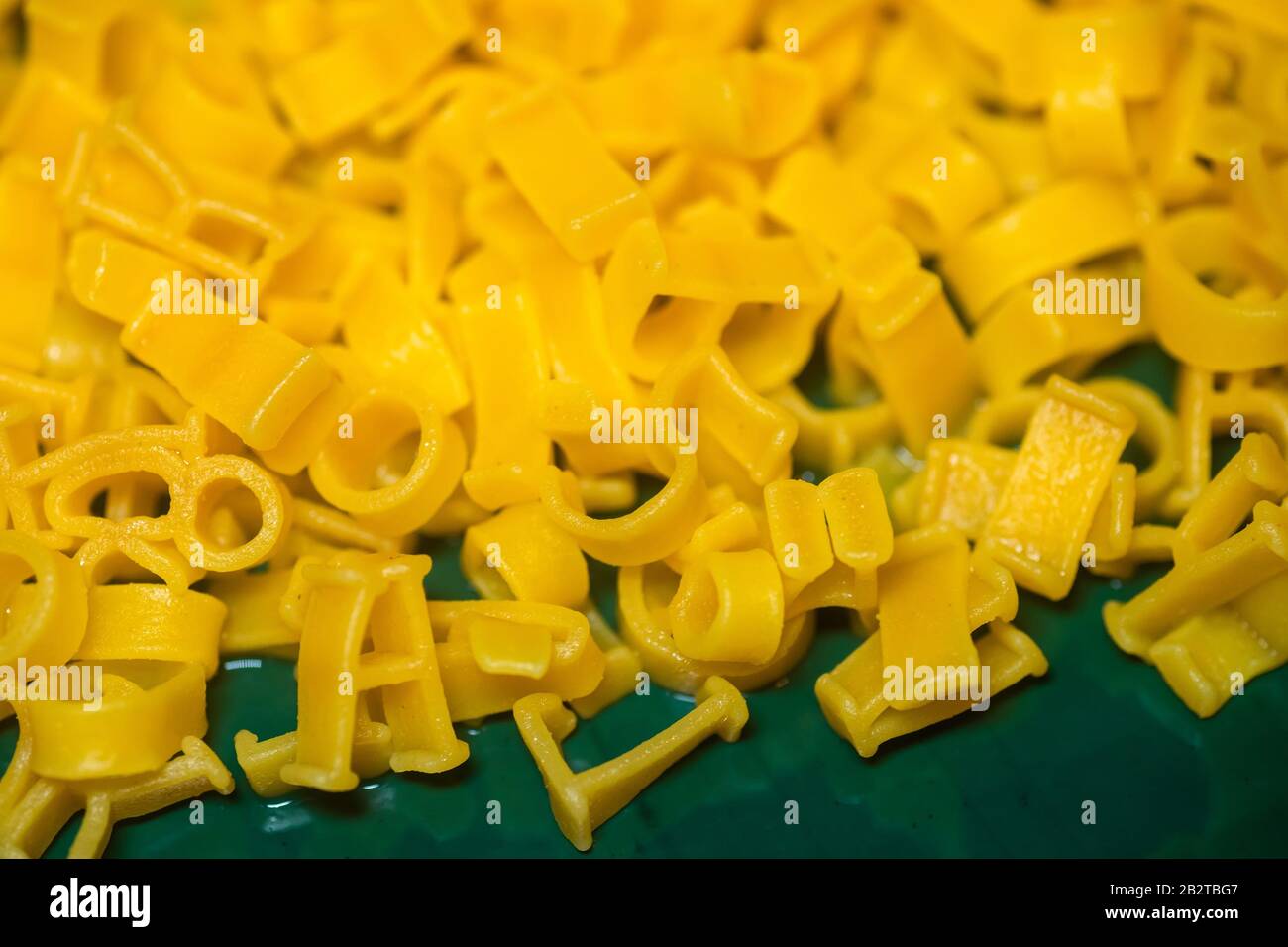 macaroni alphabet letters on a green plate. Durum wheat pasta for ...