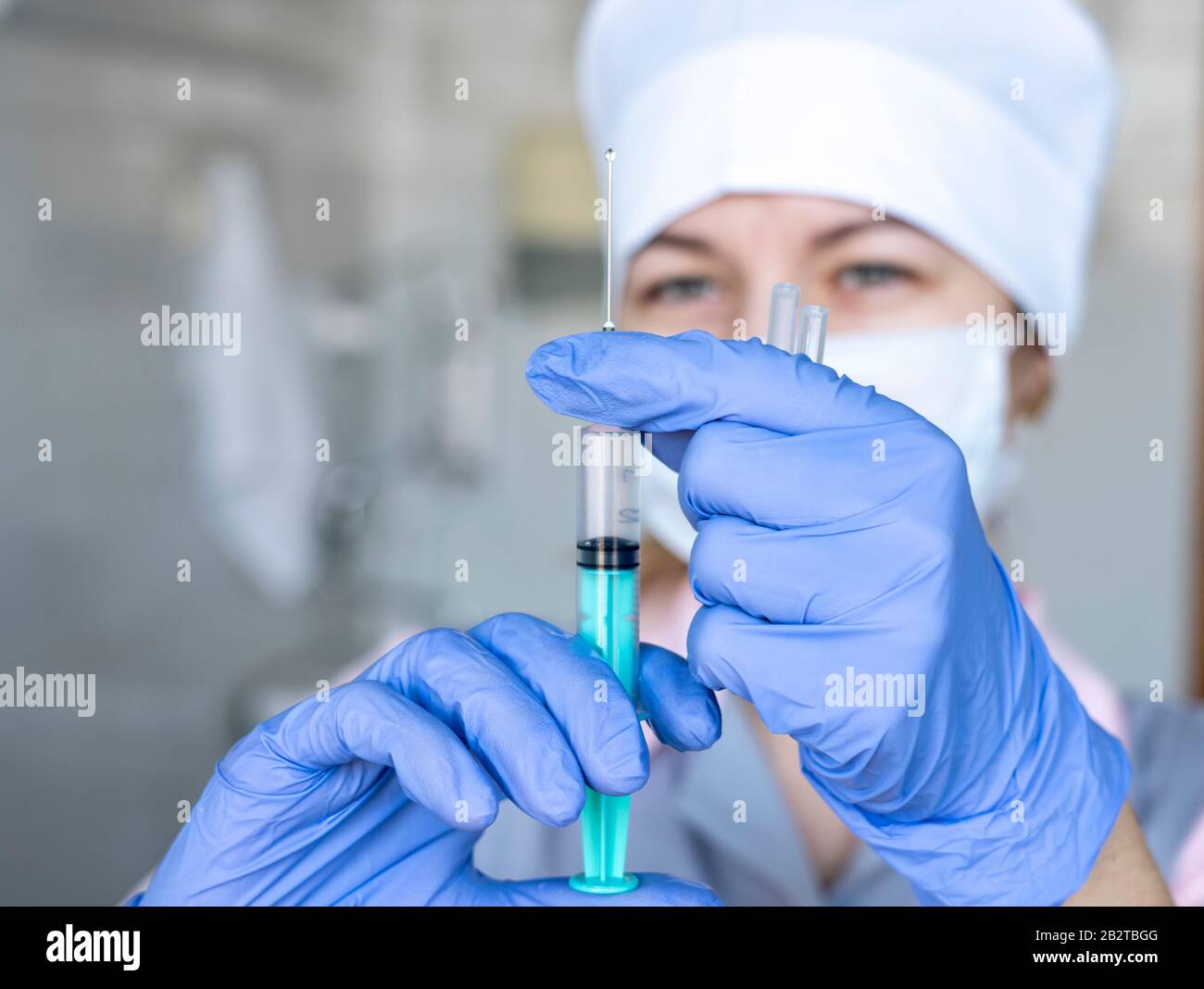 medical worker nurse close up in blue gloves with a syringe in her ...