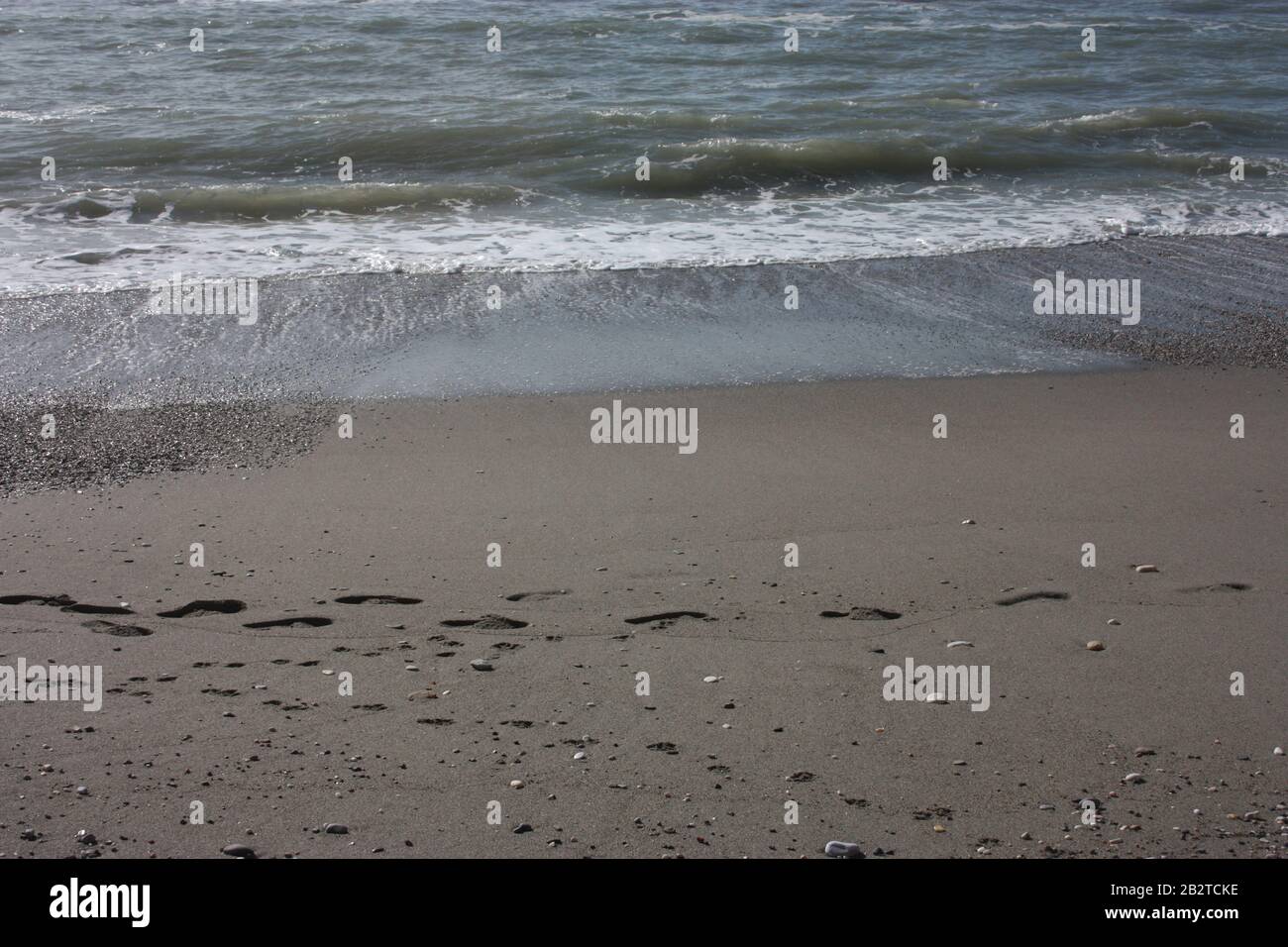 A winter beach with rough seas with cold and dull colors in the ...