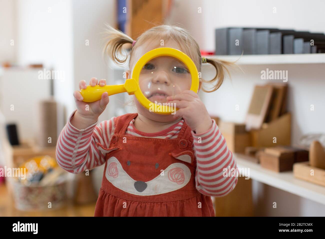 Toddler looking through magnifying glass Stock Photo - Alamy