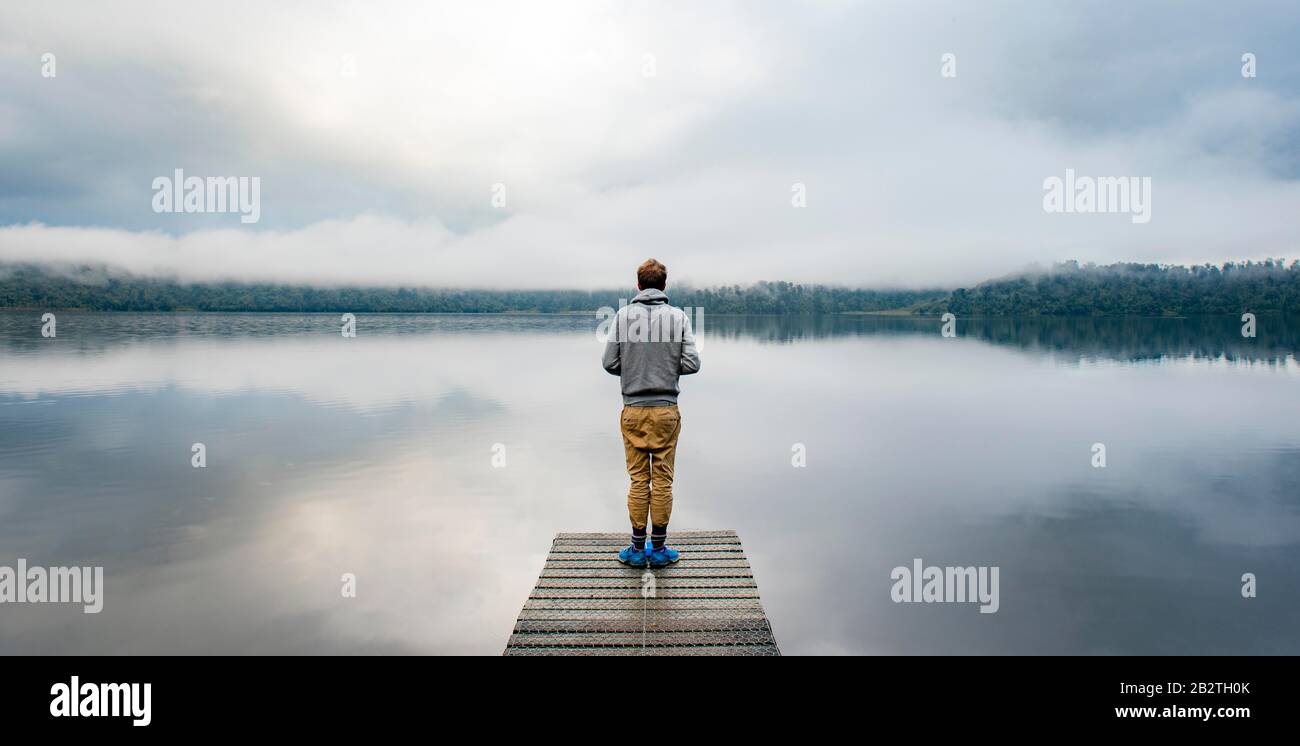 Man standing jetty looking lake hi-res stock photography and images - Alamy
