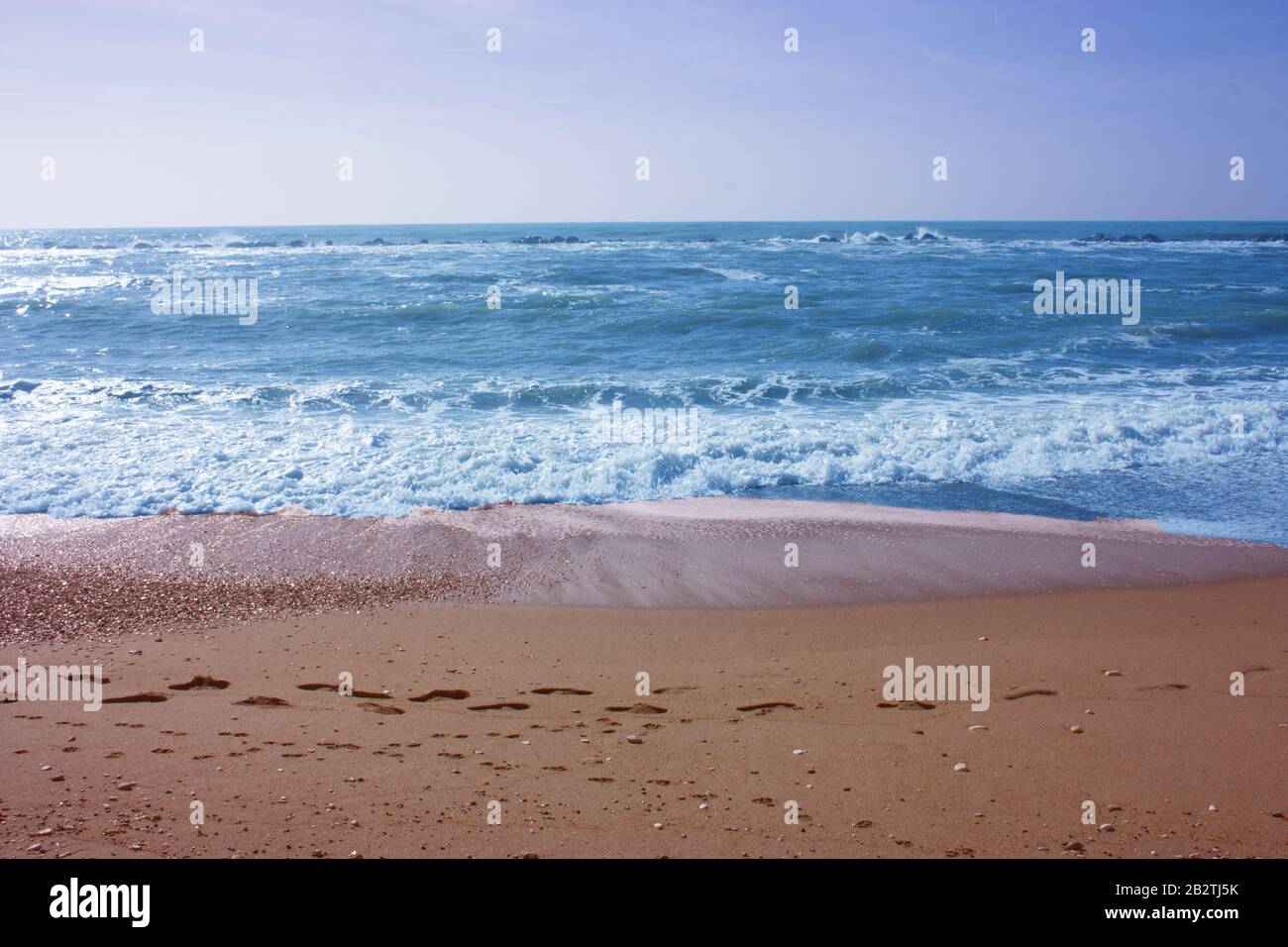 A winter beach with rough seas with cold and dull colors in the ...