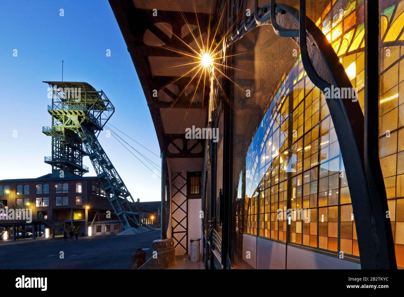 Illuminated machine hall with winding tower in the evening, Zollern ...