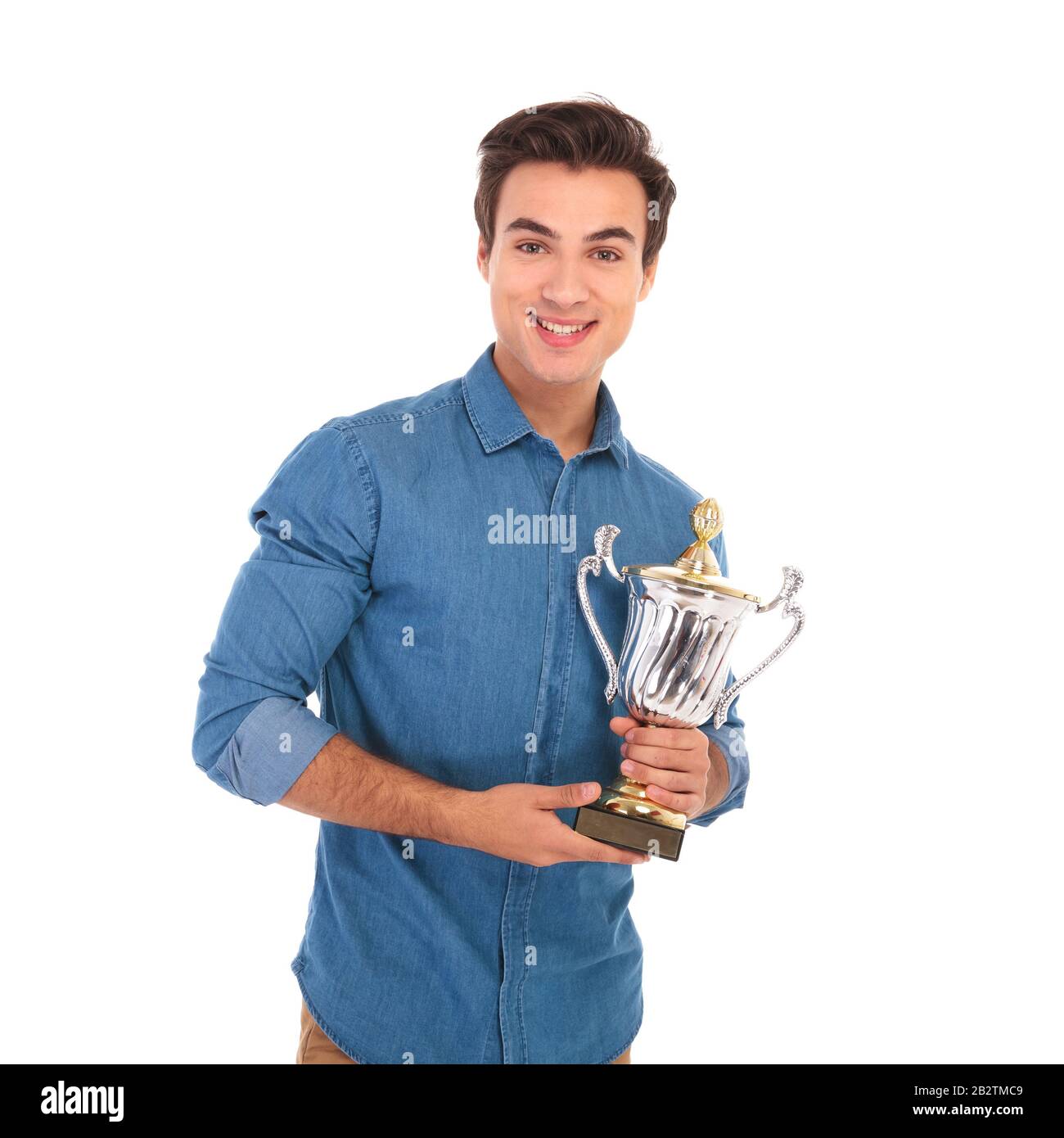 happy young winner holding his trophy prize and smiles on white ...