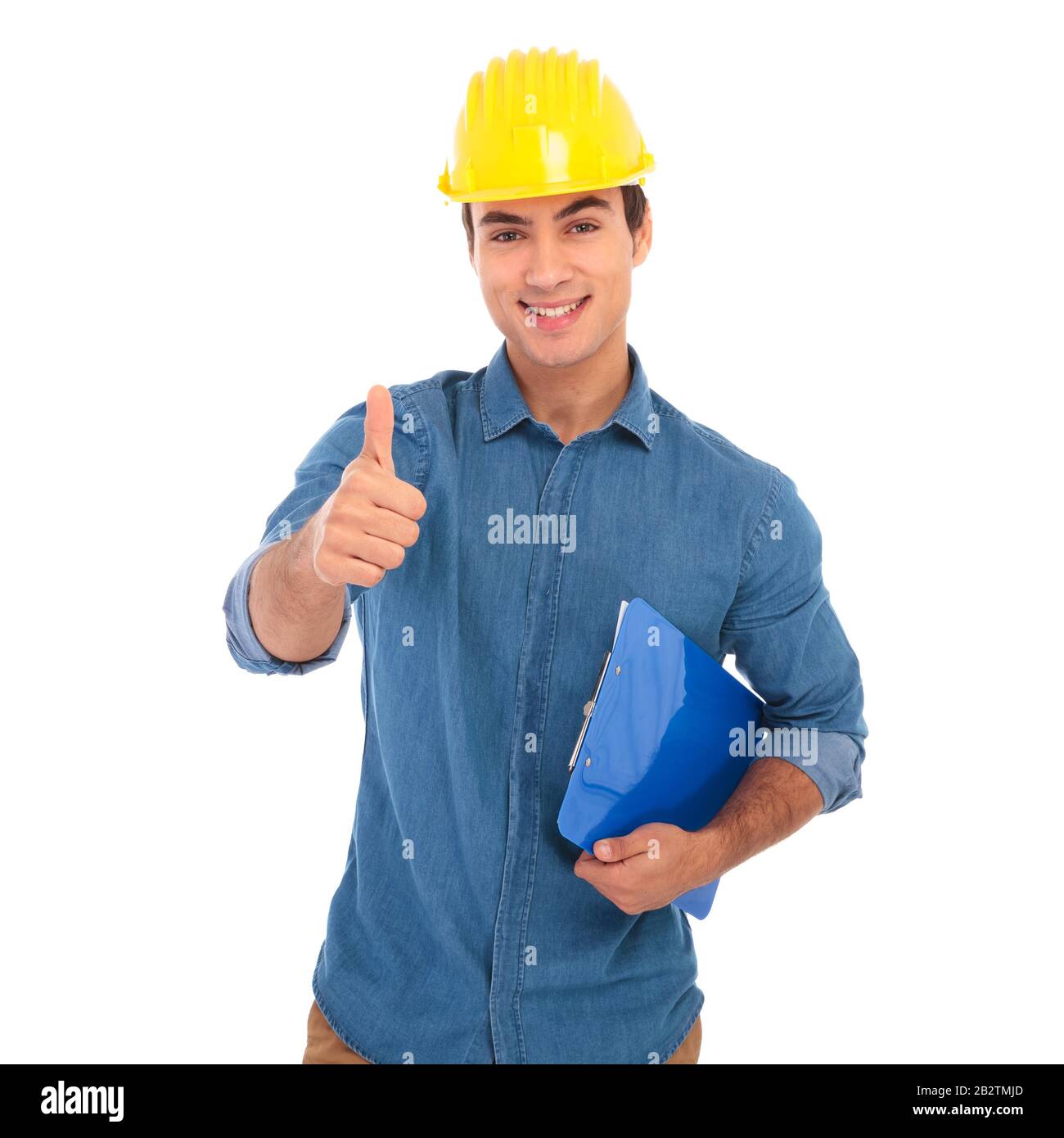 smiling young construcion engineer making the ok thumbs up hand sign on ...