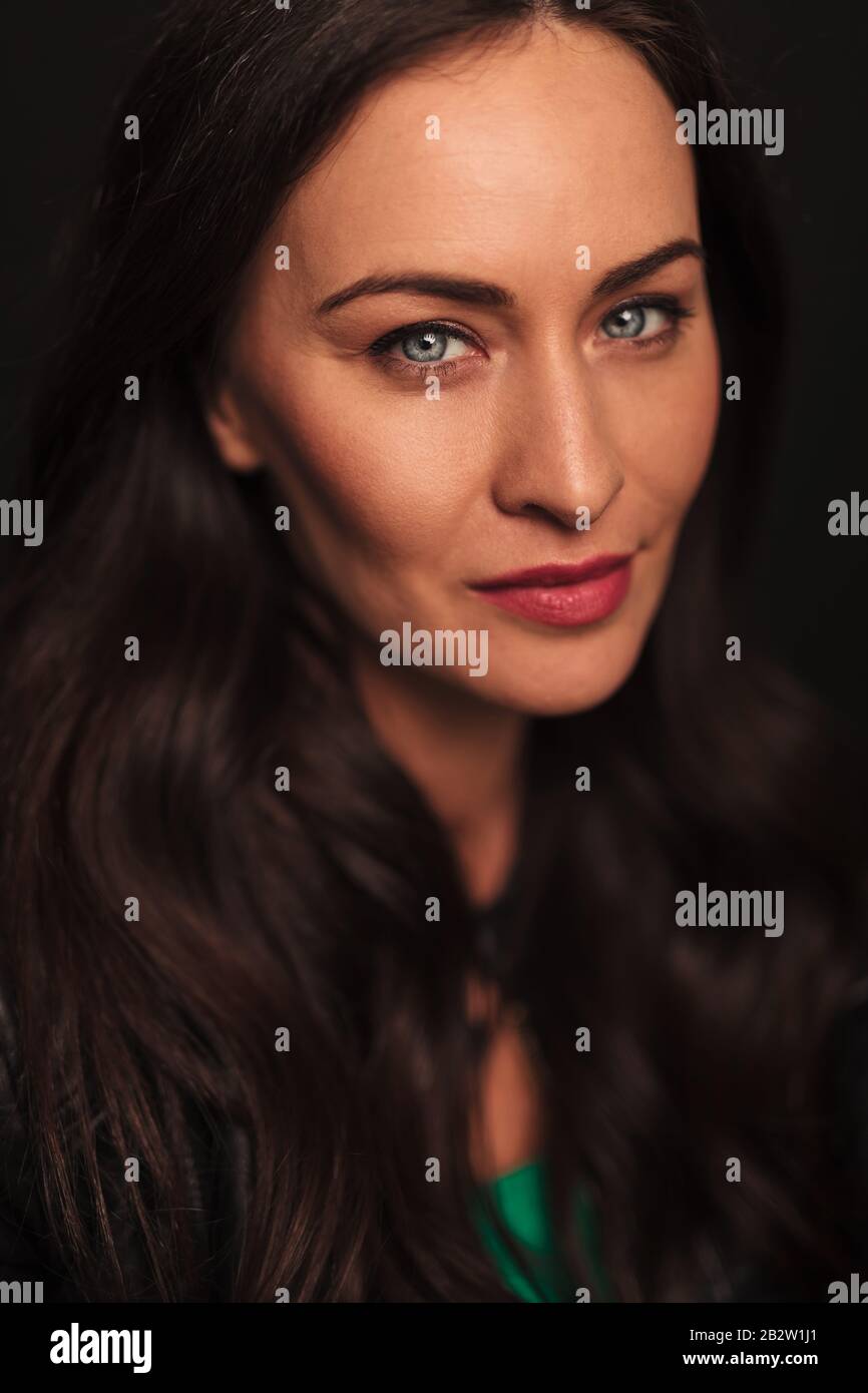 portrait of a young woman with blue eyes on black studio background ...