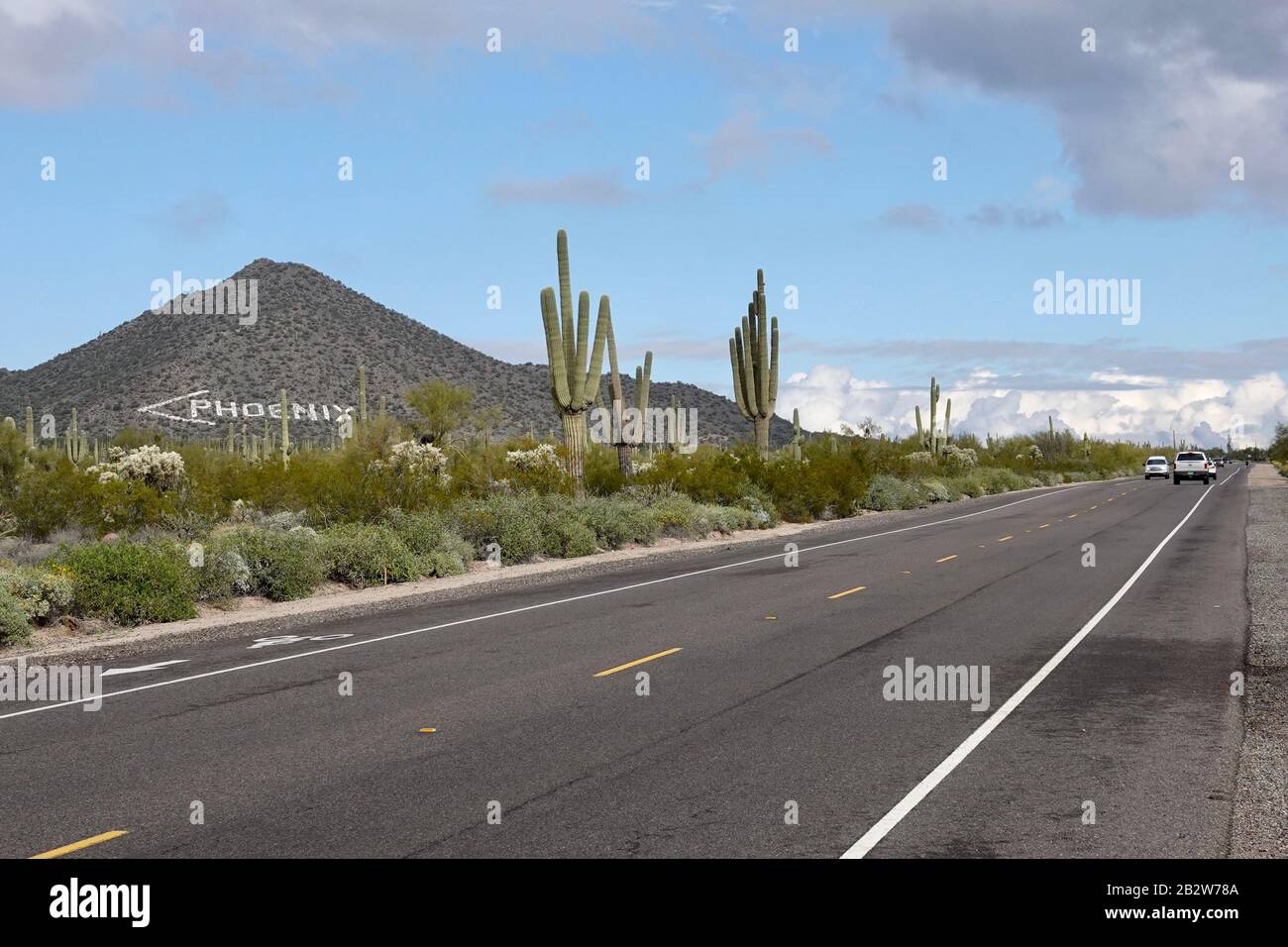 A sign made of white rocks built on a mountainside says Phoenix with an ...