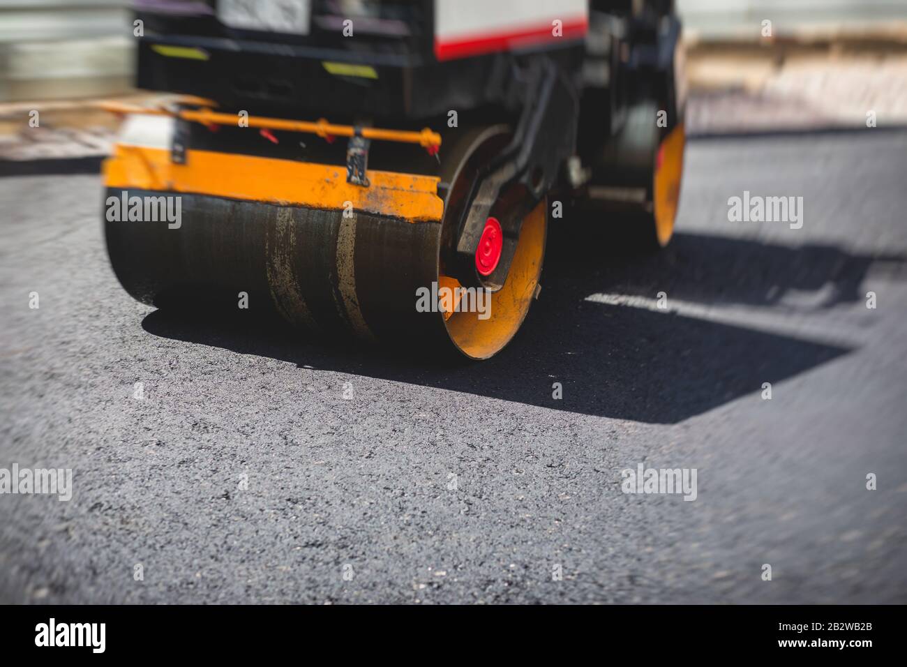 Asphalt paver machine and steam road roller during road construction ...