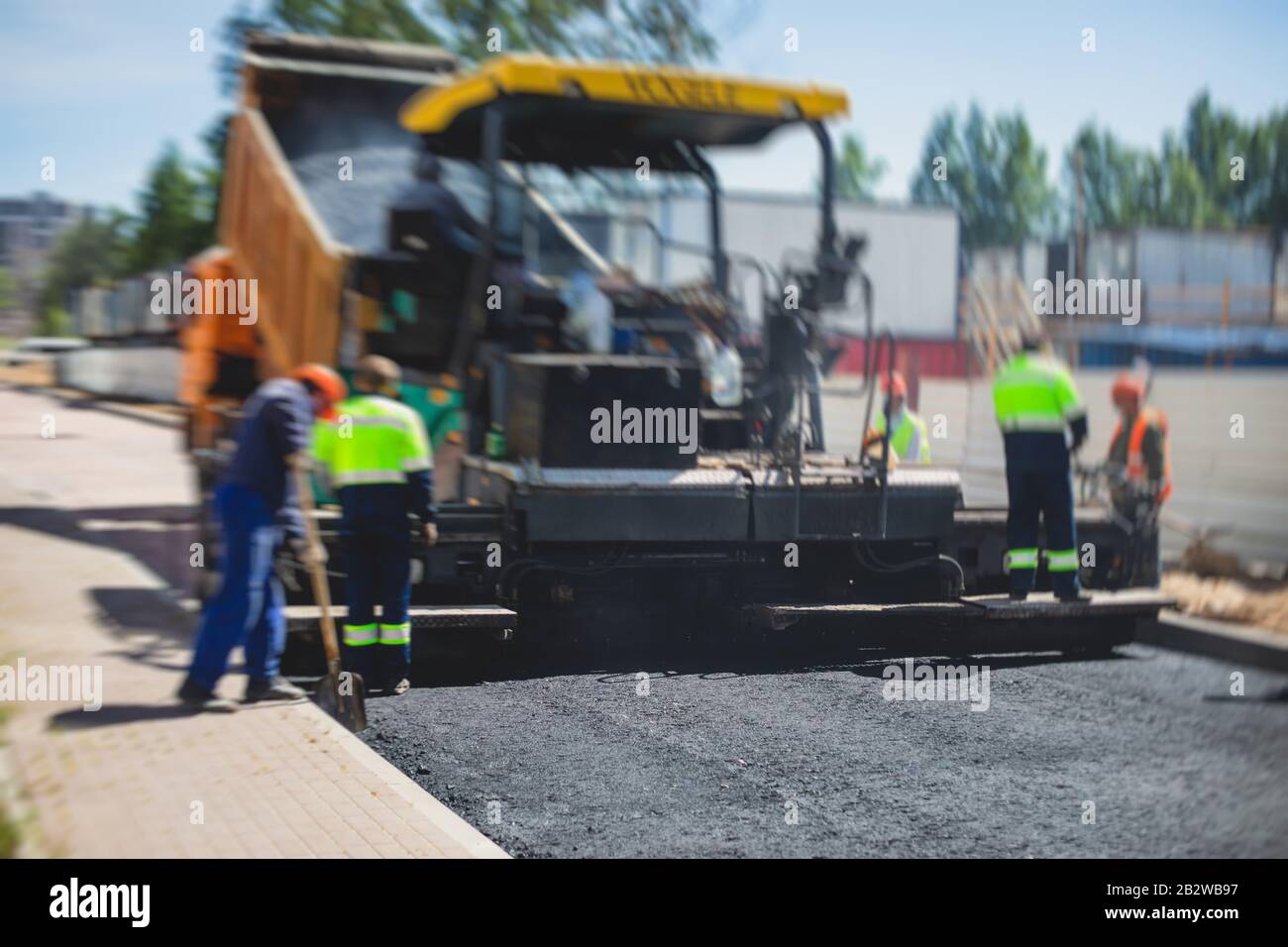 Asphalt paver machine and steam road roller during road construction ...