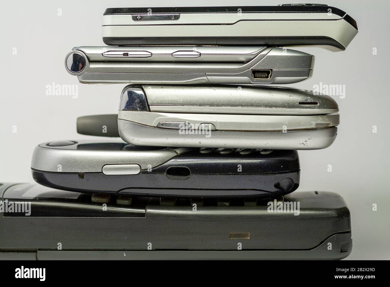 Stacked old mobile phones on white background Stock Photo - Alamy