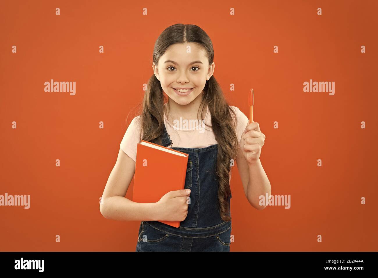 writing notes. kid diary. school girl read book on orange background ...
