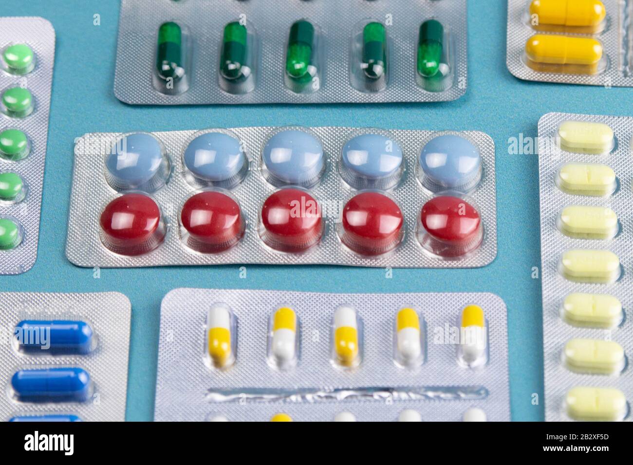 Pills of different colours lay on blue background. Colorful ...