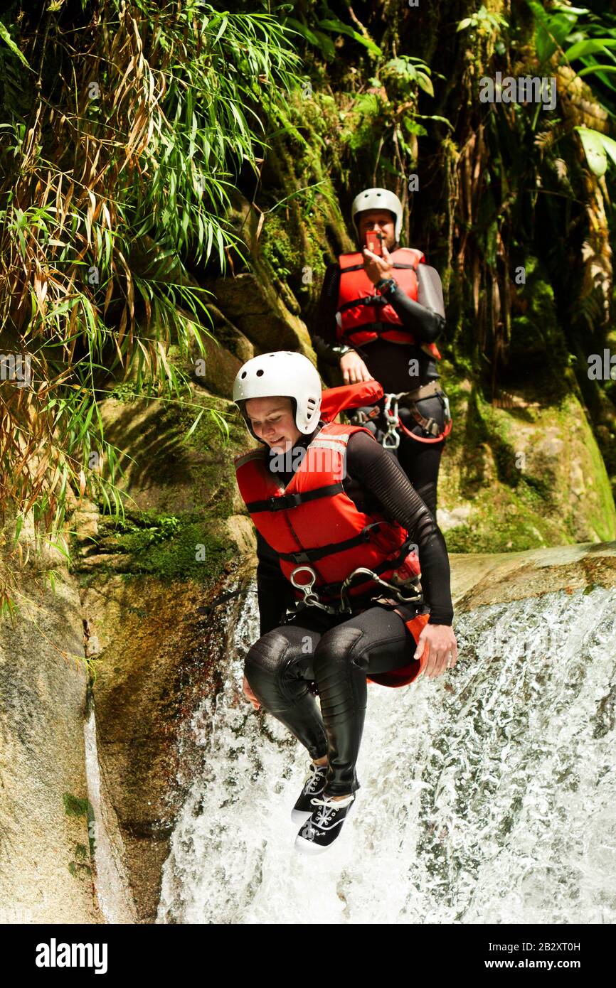 Young Woman Jumping Into A Waterfall While Being Photographed Stock ...