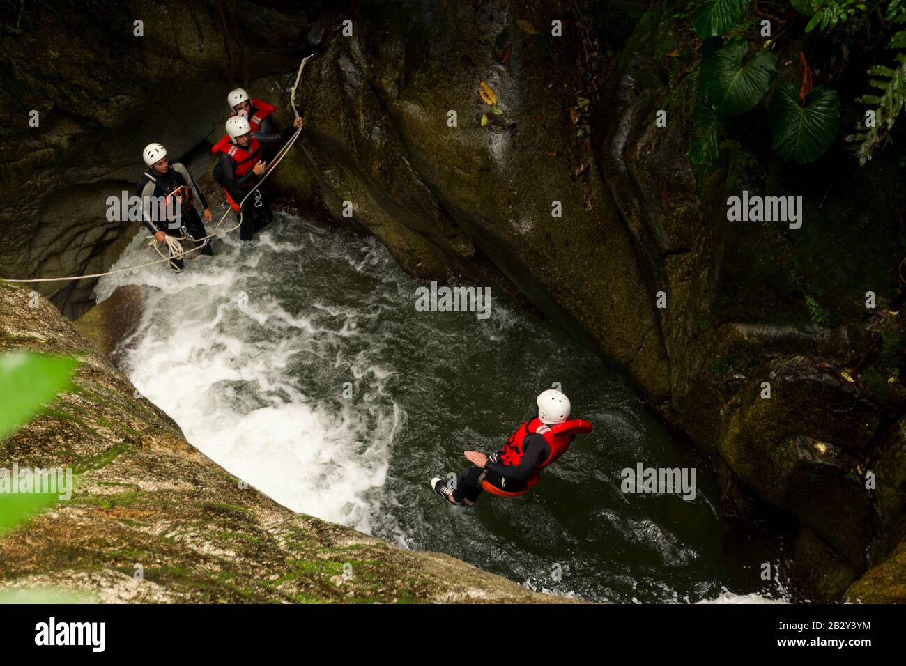 Well Equipped Man Jumping Into A Natural Pool During A Canyoning ...