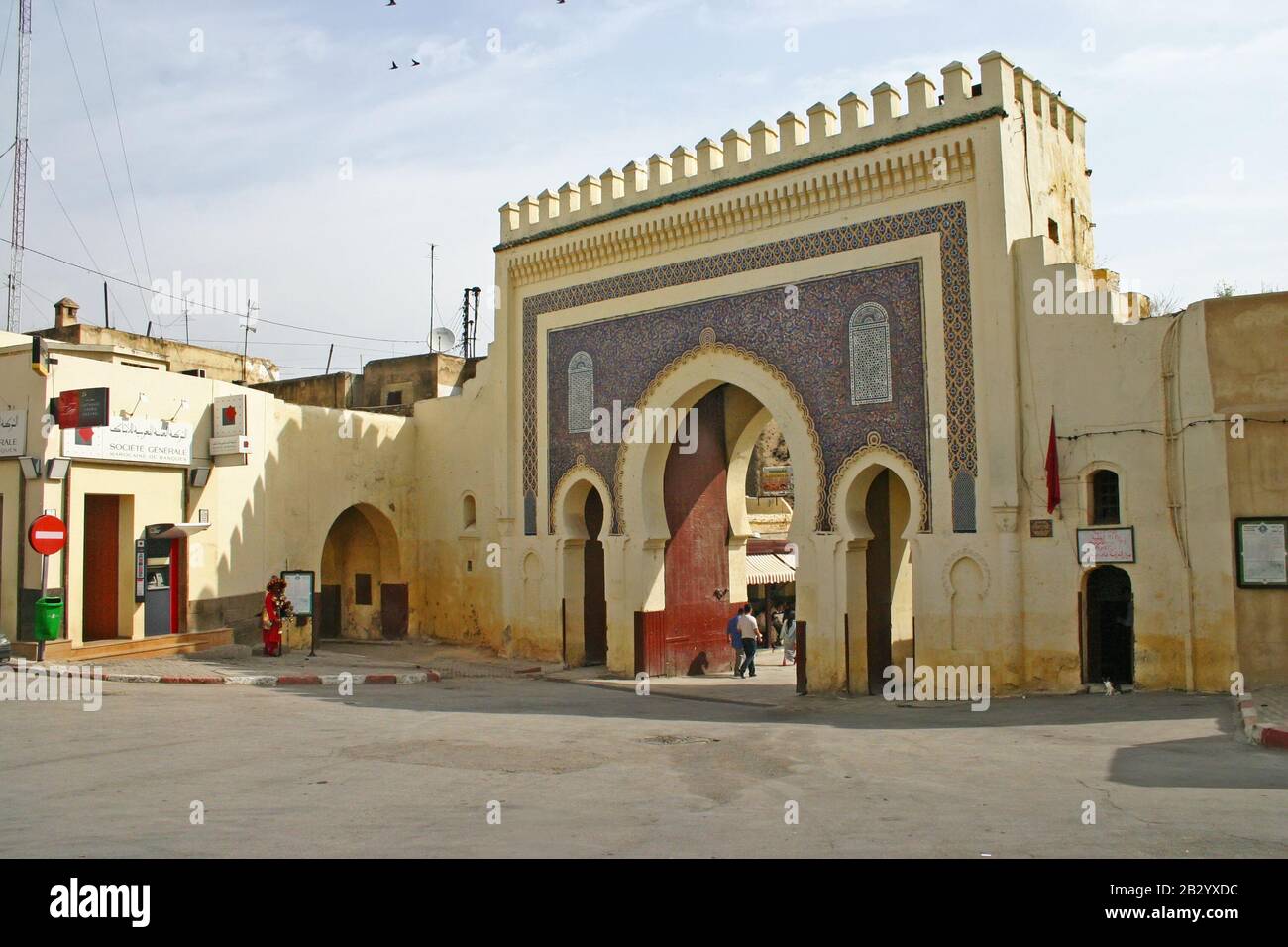 Pedestrians walk through the Bab Bou Jeloud (or Blue Gate), the main ...