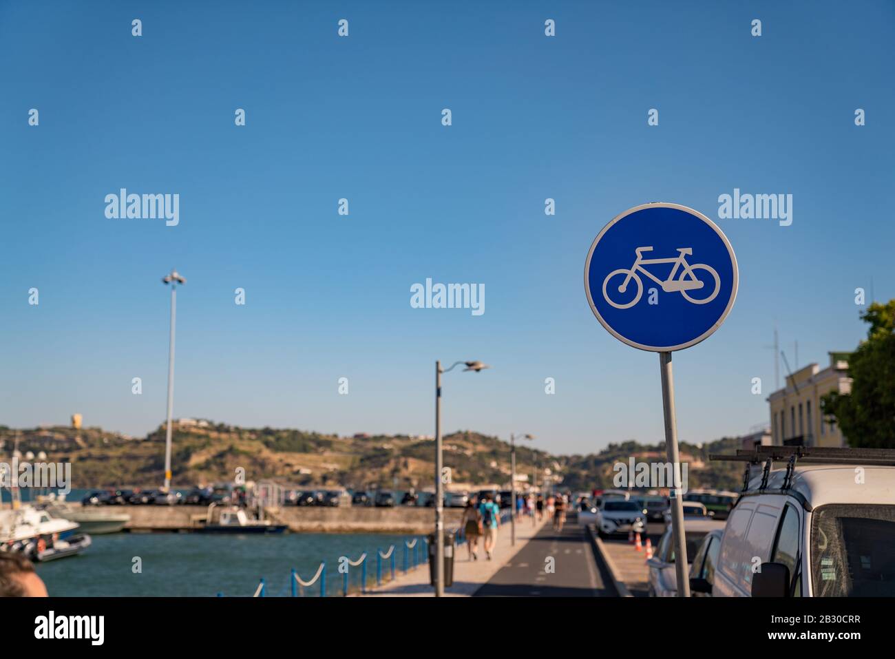 Bike path area and blue bike sign in pedestrian area near bay Stock ...