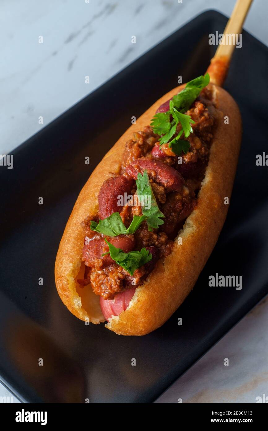 American fast-food chili corn dog on marble kitchen table Stock Photo ...