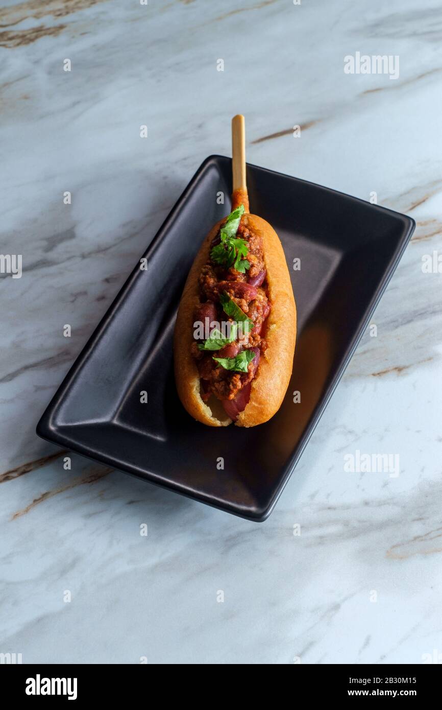 American fast-food chili corn dog on marble kitchen table Stock Photo ...
