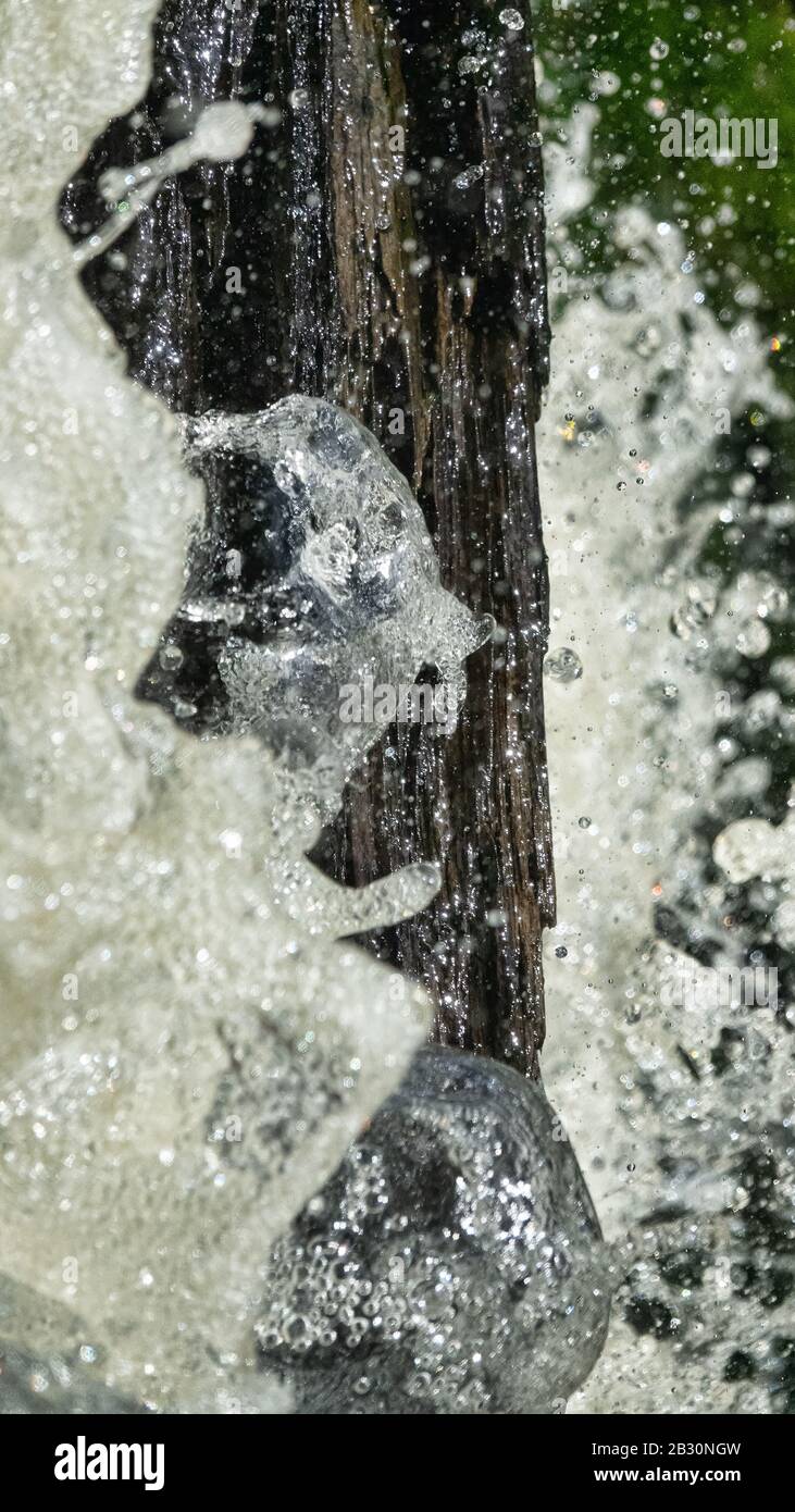Water backgrounds with foam spray fast flow.The log is stuck in ...