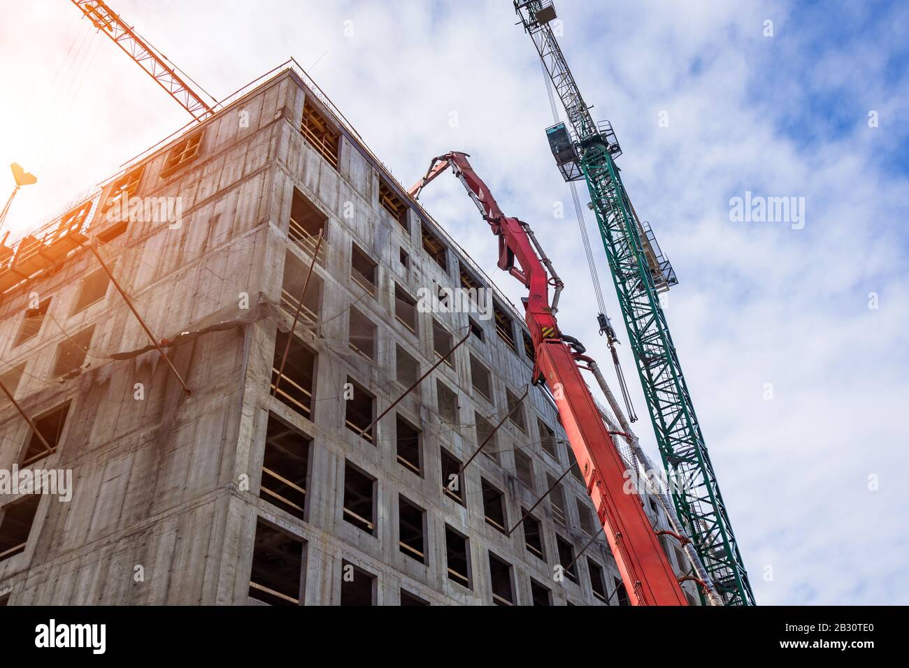 Pouring concrete to the upper floors of a building under construction ...