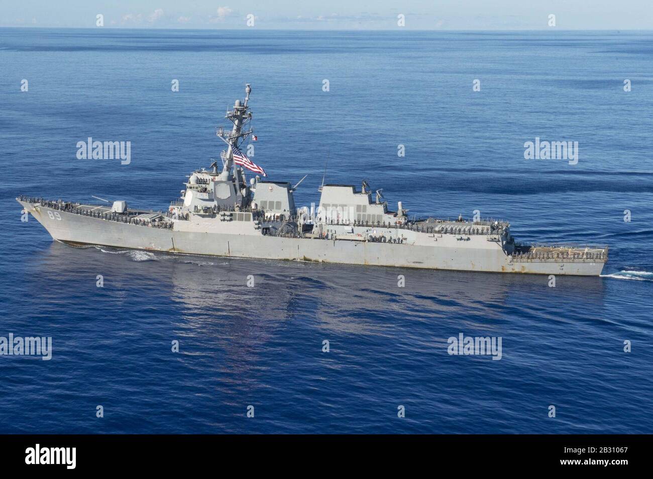 General view of USS Mustin (DDG-89) with sailors manning rails near ...