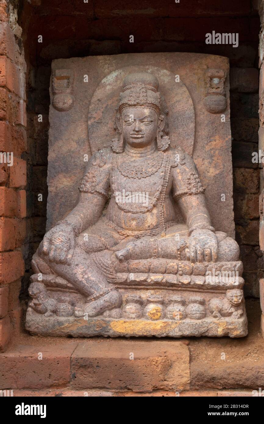 Sculpture of a deity in niche seated on double lotus throne of ...