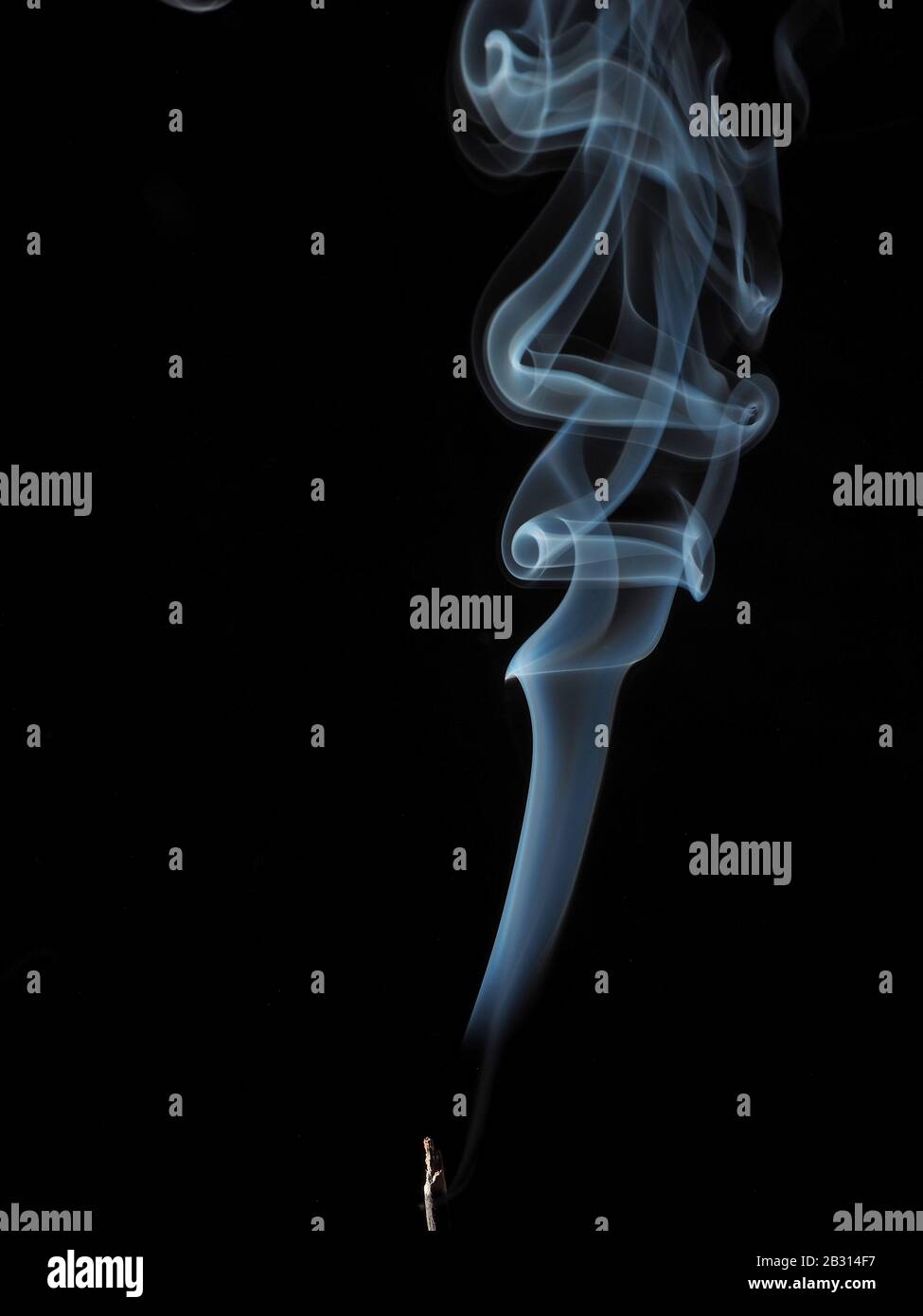 Incense with beautiful smoke on a dark background Stock Photo - Alamy